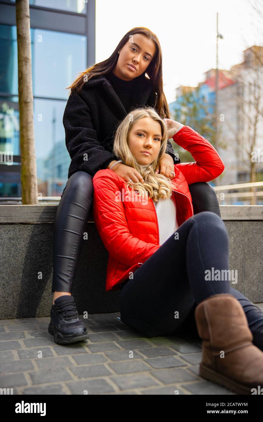 Portrait Of Two Best Friends Sitting Togehter In City Stock Photo - Alamy