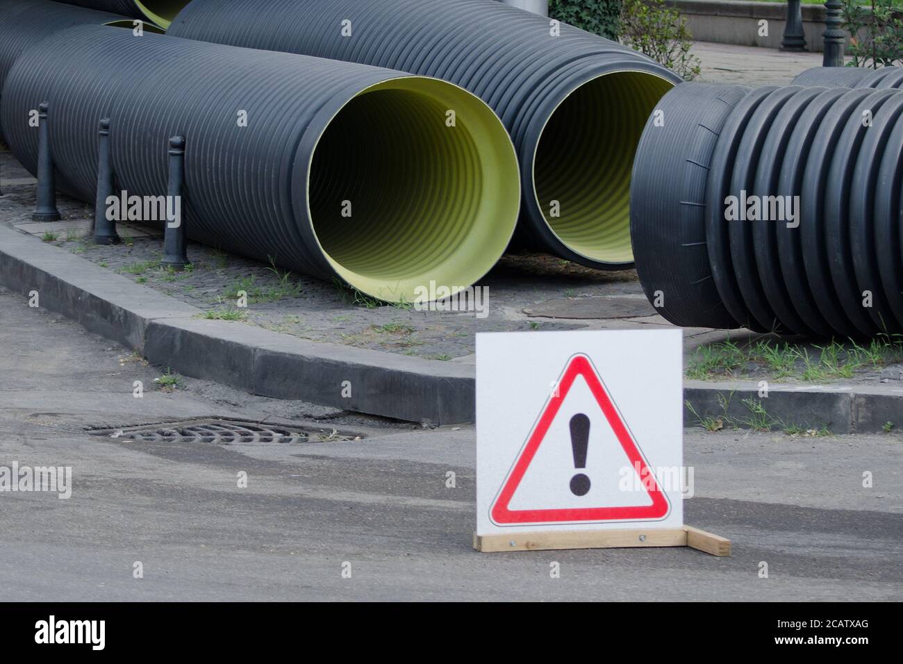 Replacement of pipes in the city. Large new pipes. Caution sign Stock ...