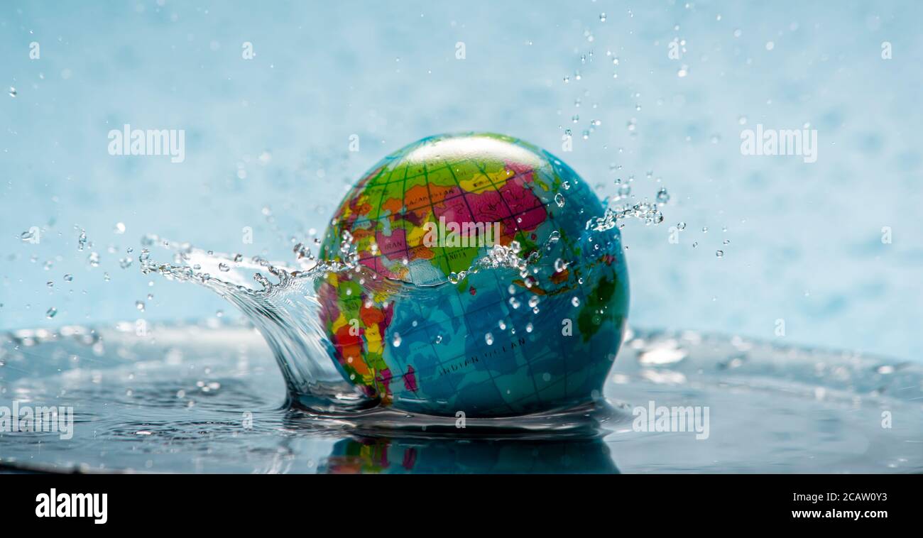 Planet Earth in the form of a globe in transparent water with splashes ...