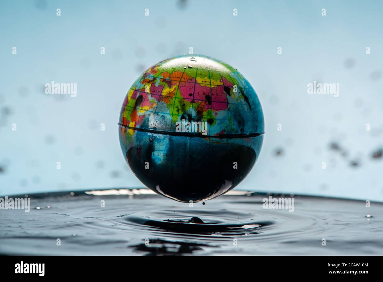 Earth in the form of a globe is falling into the oil and made a ...