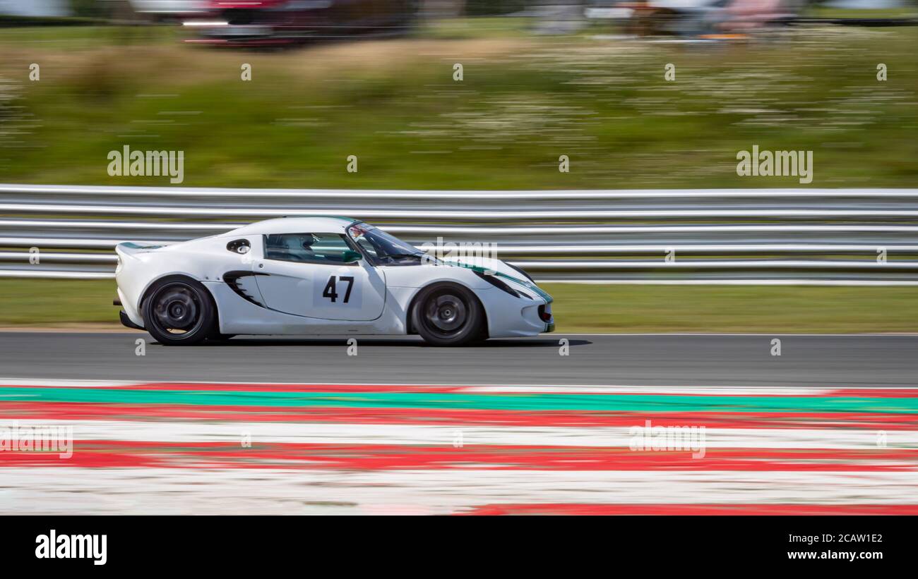 A panning shot of a white racing car as it circuits a track Stock Photo ...
