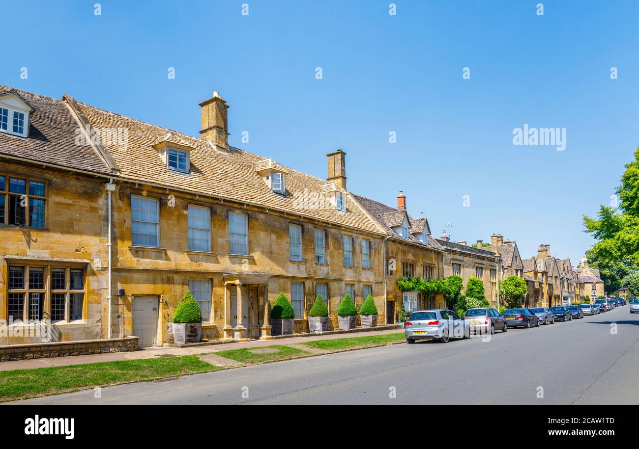 A roadside view of High Street with traditional Cotswold Stone cottages ...