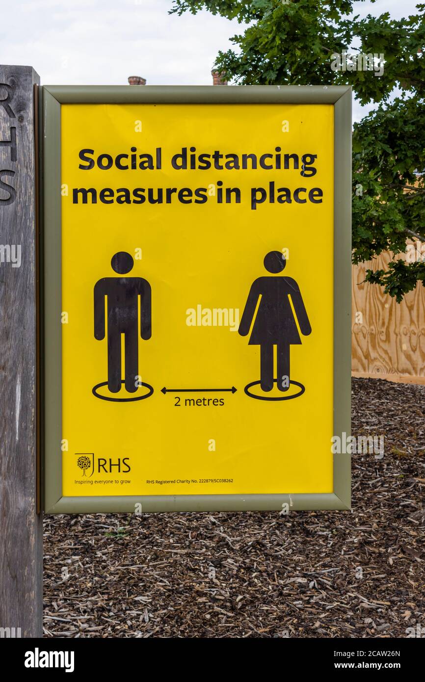Yellow and black 2m social distancing reminder sign at RHS Garden ...
