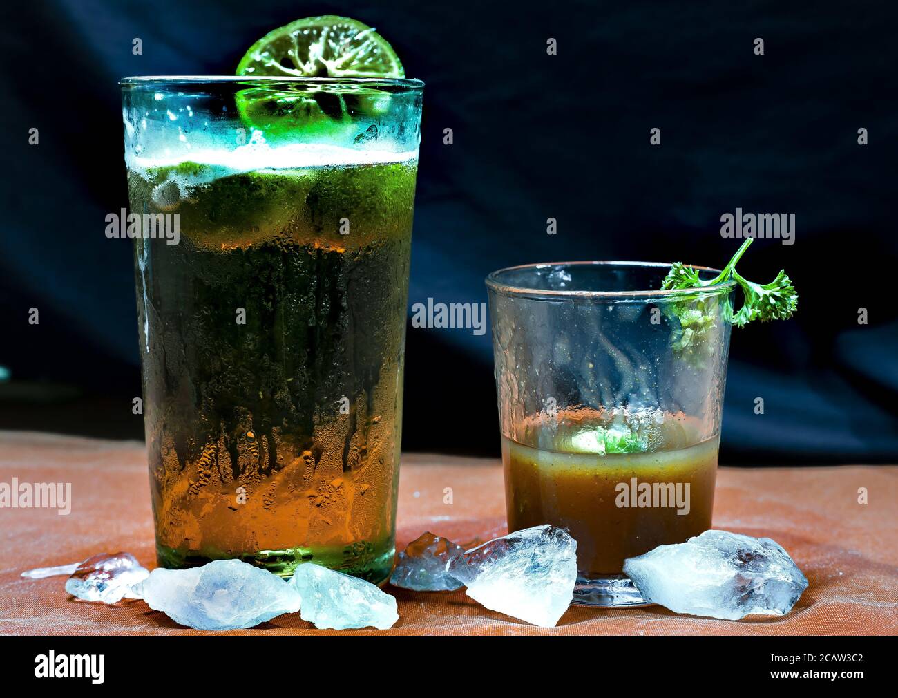 Closeup shot of two alcoholic beverages in glass cups with drops on ...
