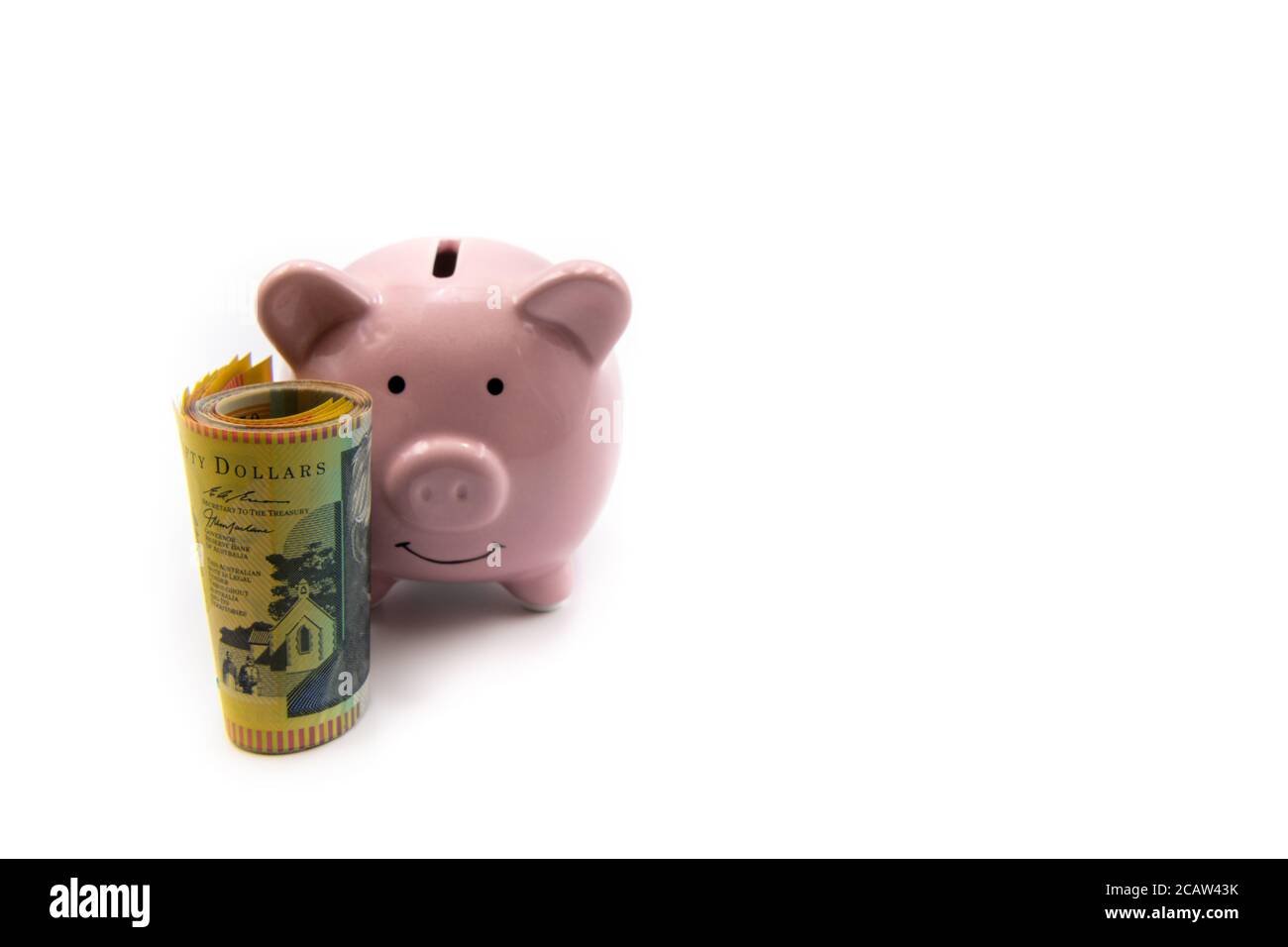 Pink piggy bank with golden crown and stack of Australian 50 dollars ...