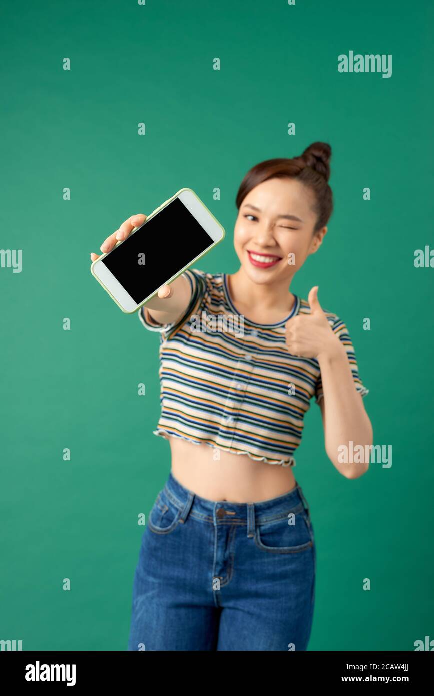 Close up portrait of a smiling Asian woman showing blank screen mobile ...