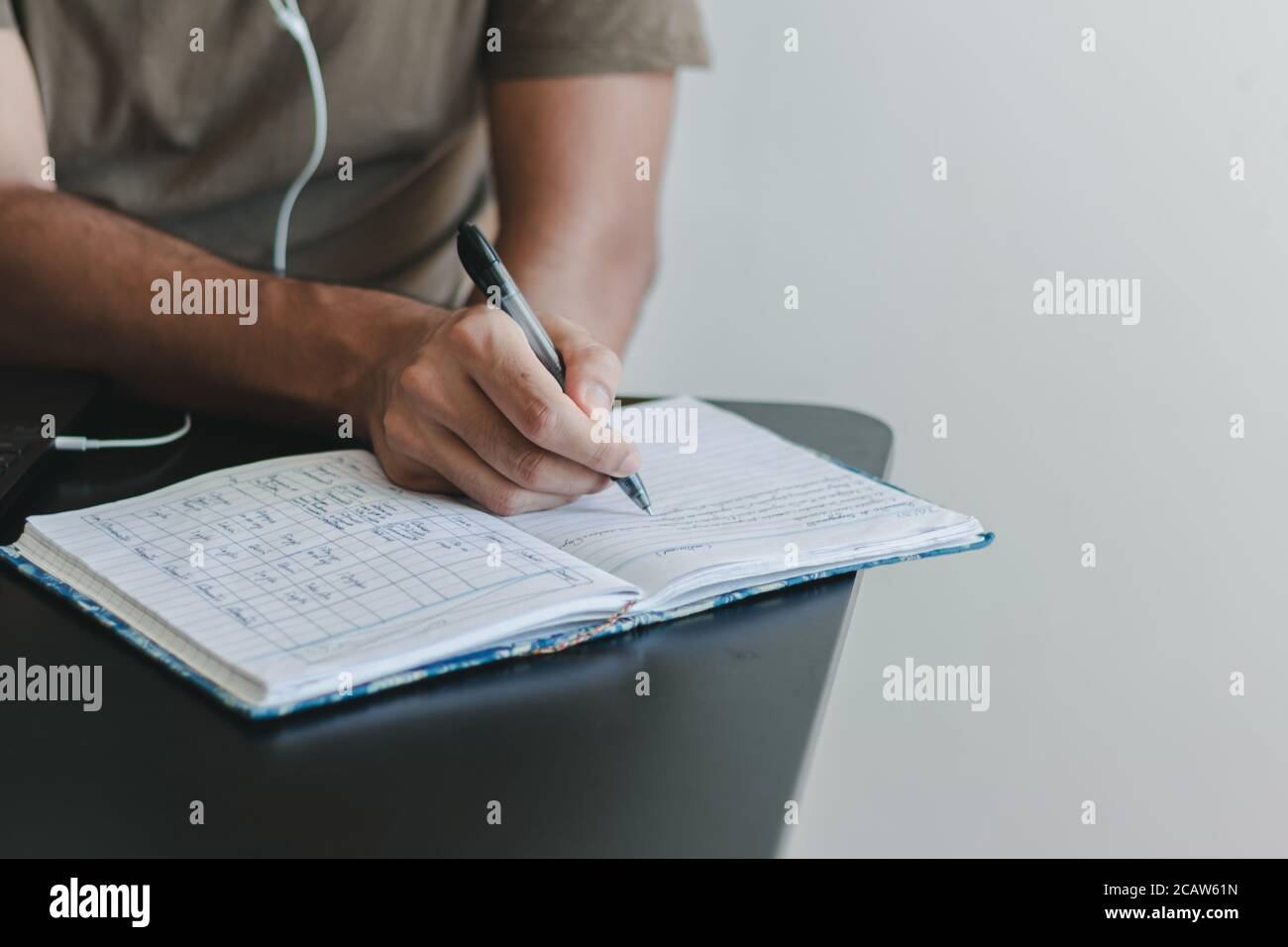 Closeup shot of male hand writing on a notebook Stock Photo - Alamy
