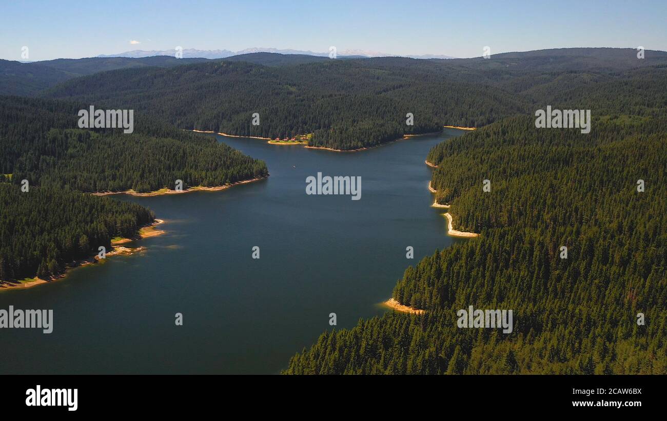 Aerial shot of a long river surrounded by hills covered in greens Stock ...