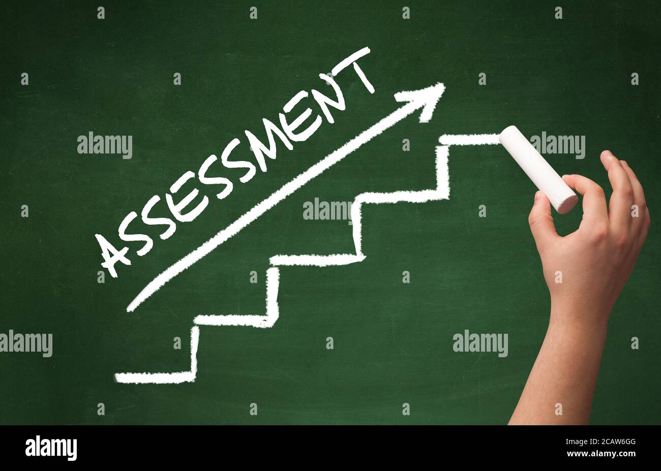 Hand drawing ASSESSMENT inscription with white chalk on blackboard ...