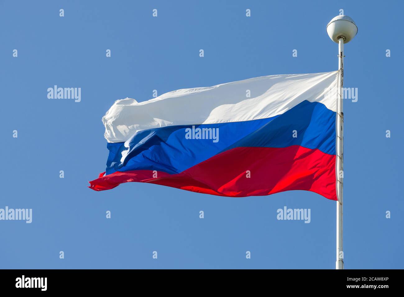 Russian flag on a flagpole against a blue cloudless sky Stock Photo - Alamy