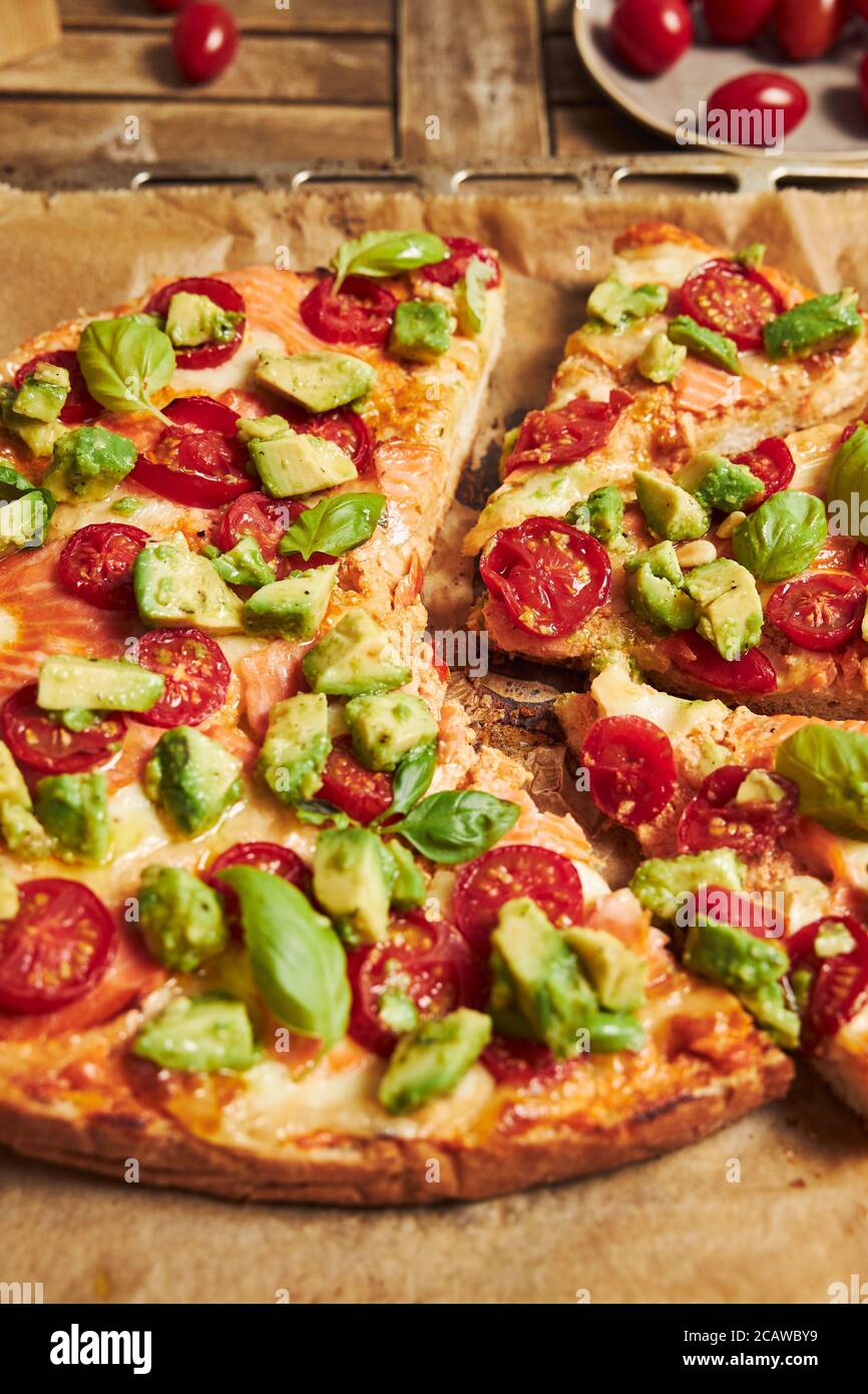 Vertical closeup shot of a pizza with vegetables on wooden table Stock ...