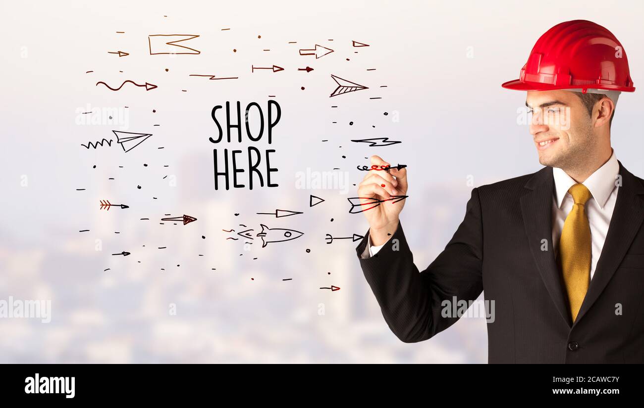Handsome businessman with helmet drawing SHOP HERE inscription ...