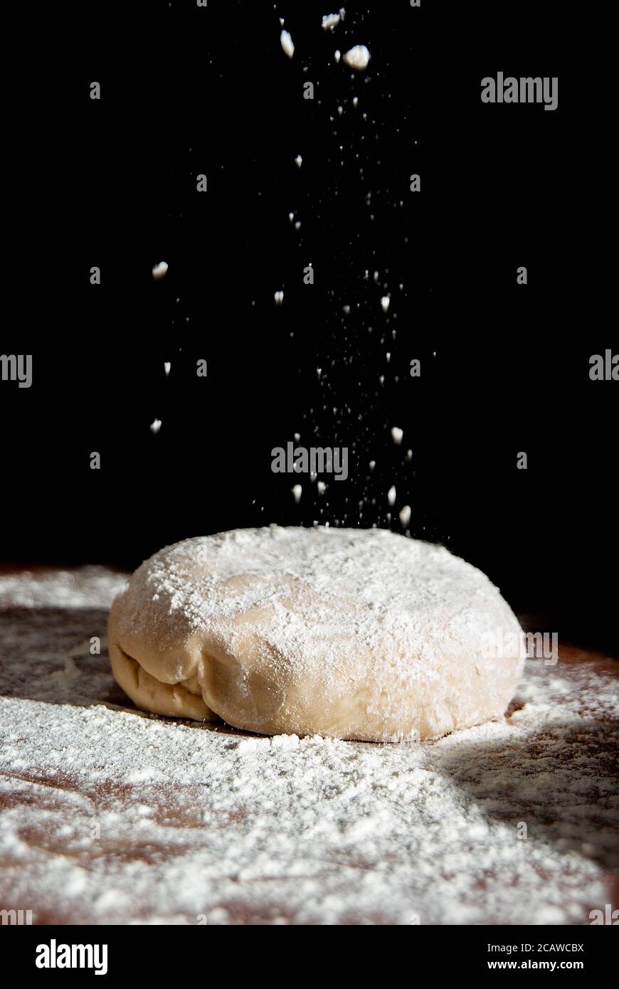 Vertical shot of throwing flour to the pizza dough Stock Photo - Alamy
