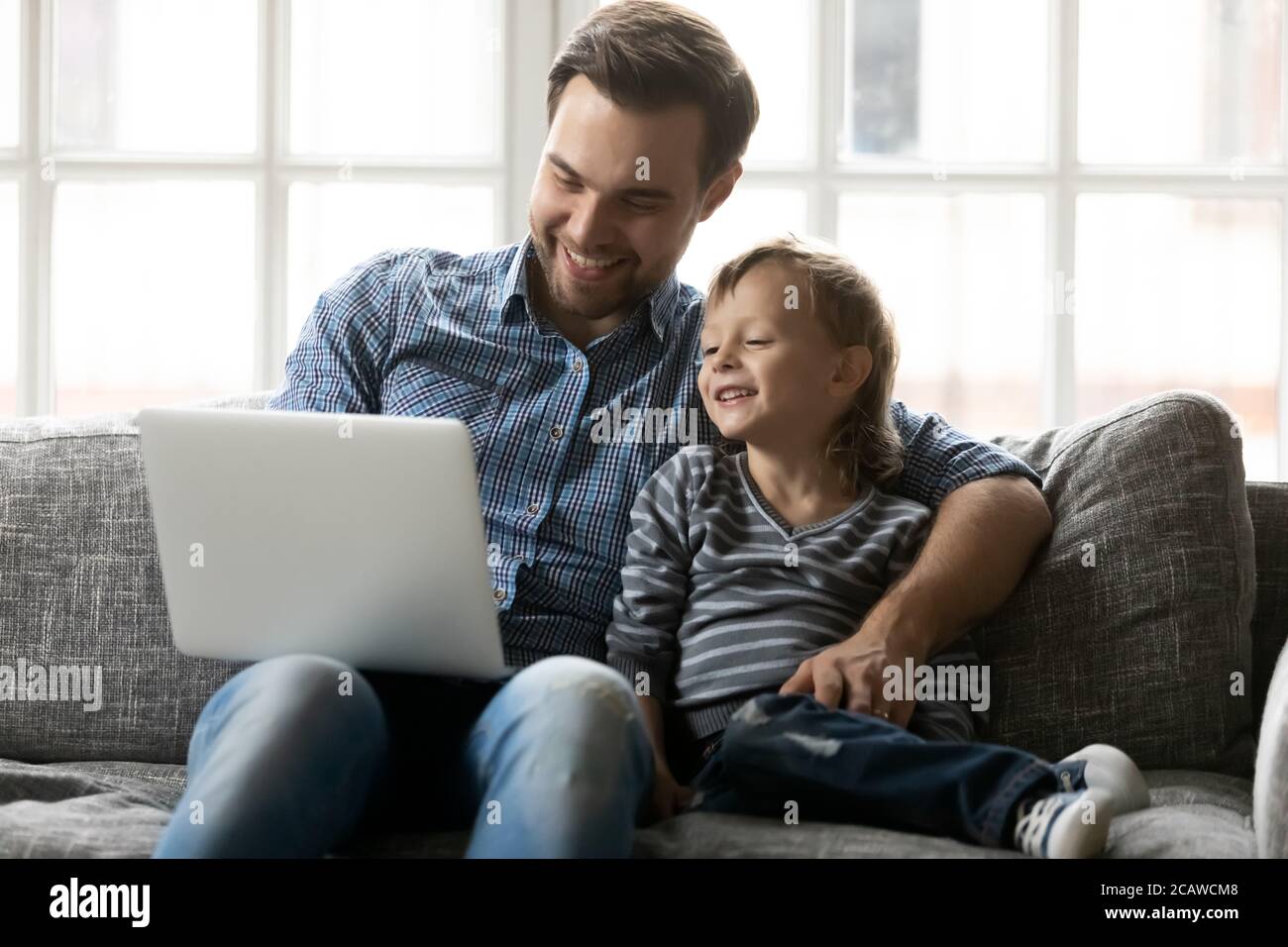 Happy two generations family enjoying watching funny cartoons Stock ...