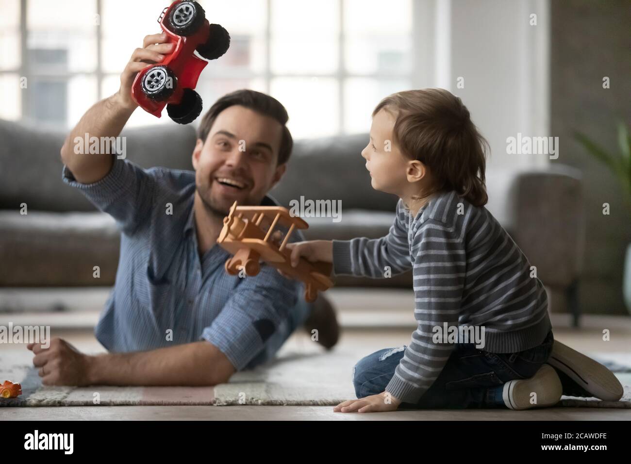 Happy young daddy playing toys with smiling little kid son Stock Photo ...