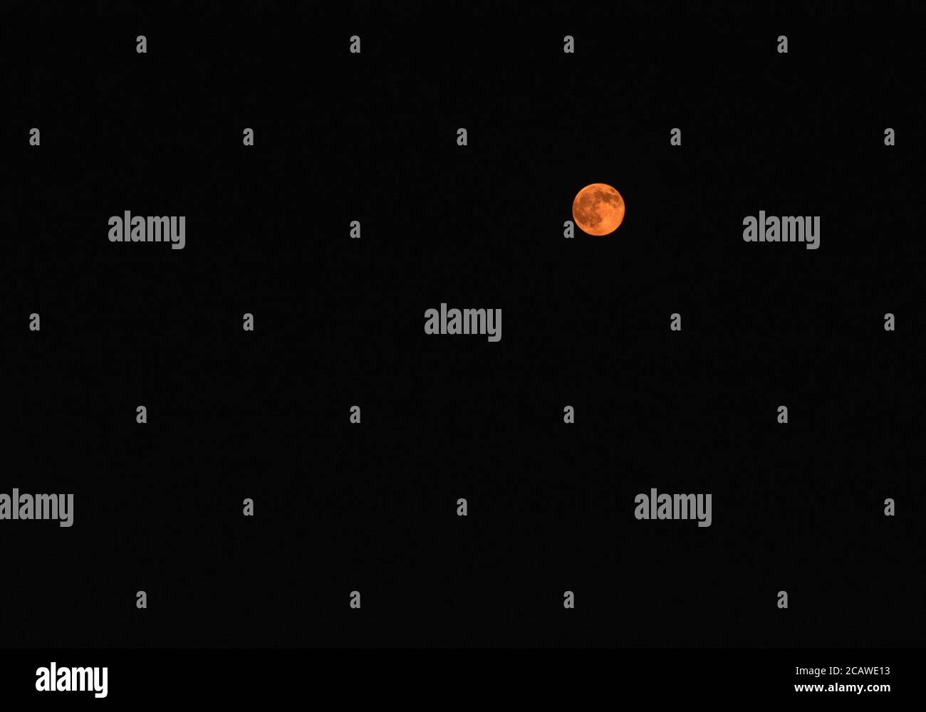 Full moon in bright orange color on a black background Stock Photo - Alamy