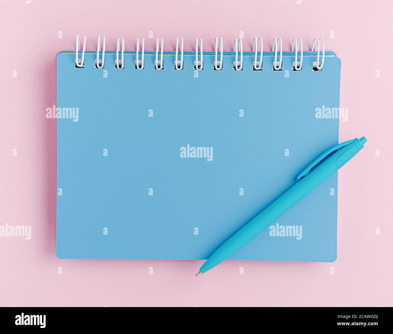 Closed blue notebook and pen on pink background. Top view, mockup Stock ...