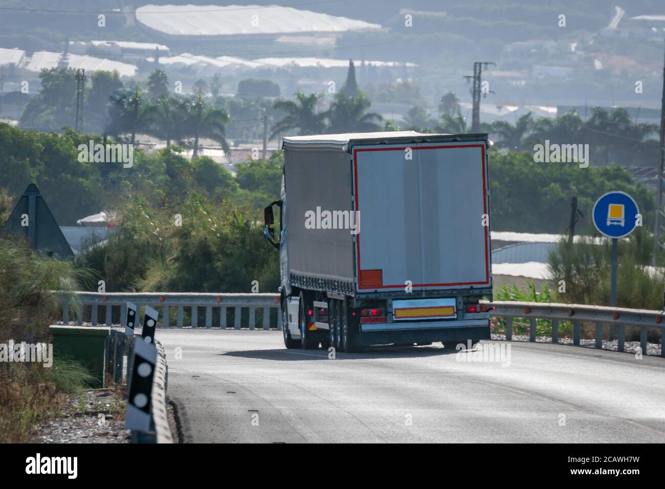 Truck with a load of dangerous goods passing by a traffic sign that ...