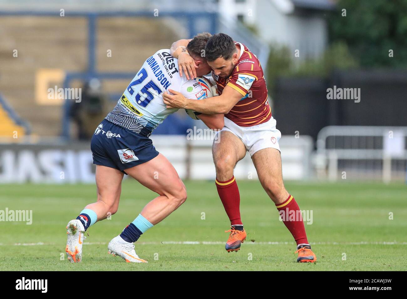 Tom Holmes (22) of Huddersfield Giants grabs James Donaldson (25) of ...