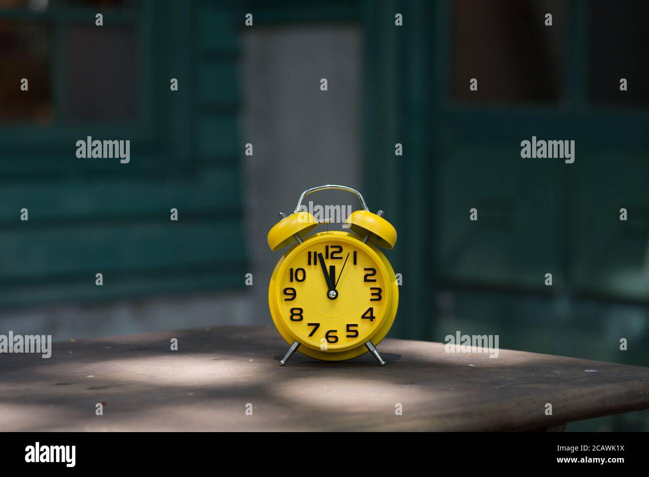 Retro alarm clock with five minutes to twelve o'clock Stock Photo - Alamy