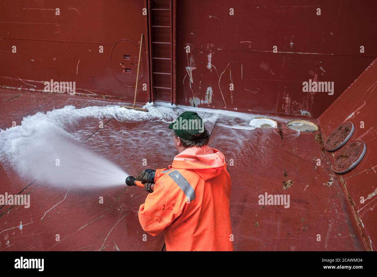 Seaman clean cargo hold with water Stock Photo - Alamy
