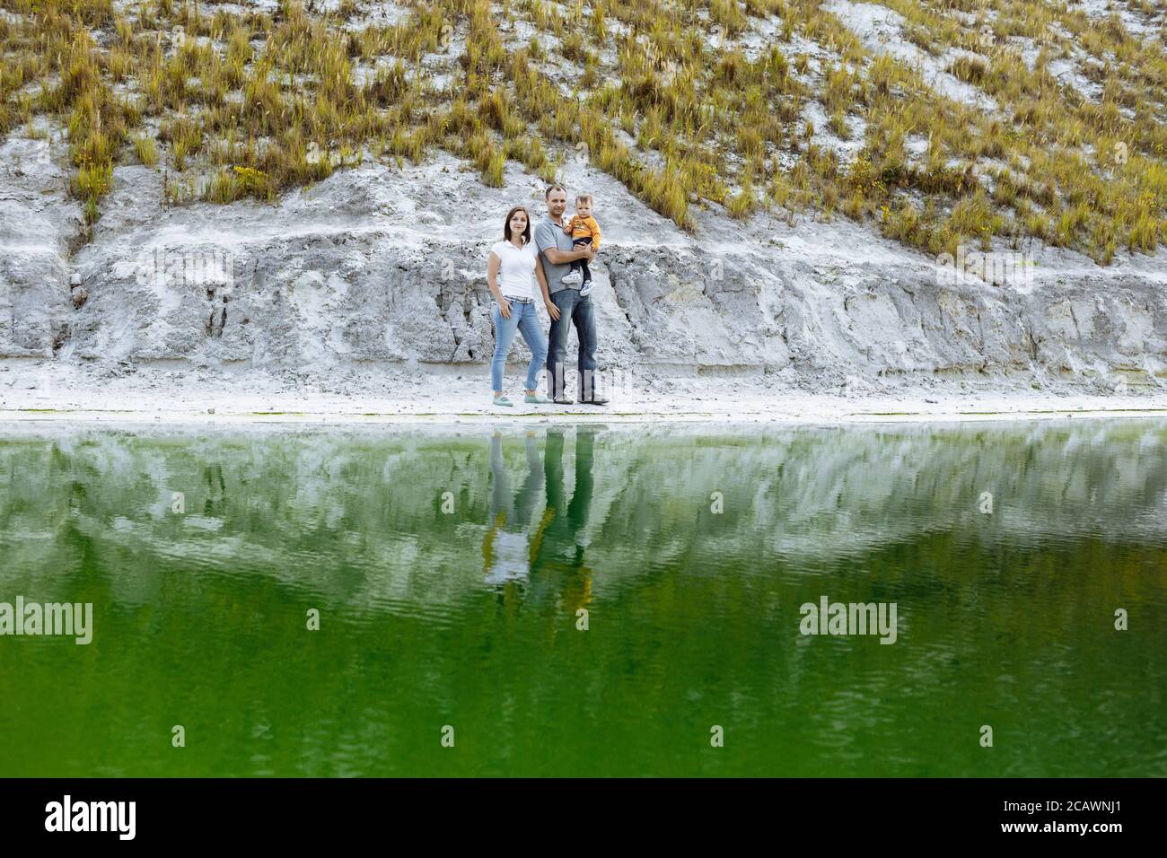 Happy young family near lake, pond. Family enjoying life together at ...