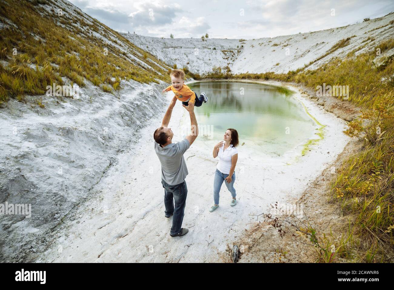 Happy young family near lake, pond. Family enjoying life together at ...