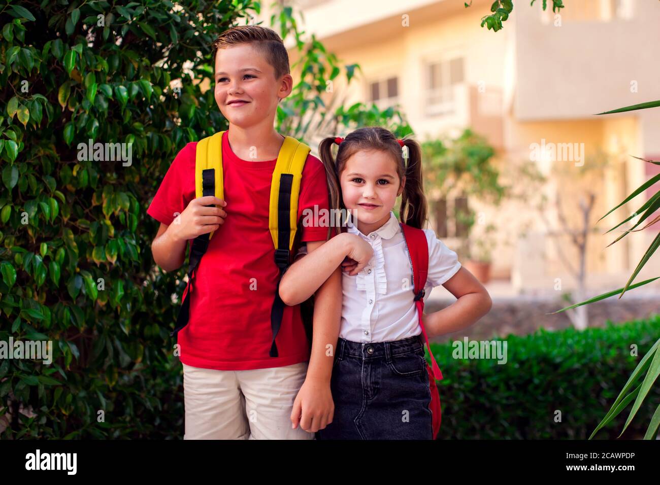 Back to school. Pupils with backpacks staying outdoor Stock Photo - Alamy