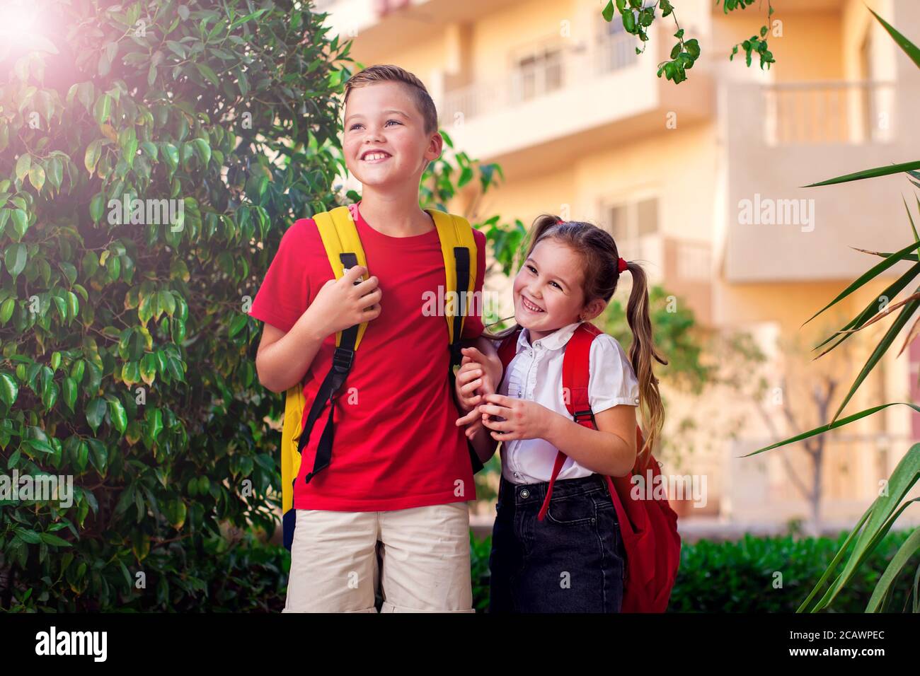 Back to school. Pupils with backpacks staying outdoor Stock Photo - Alamy