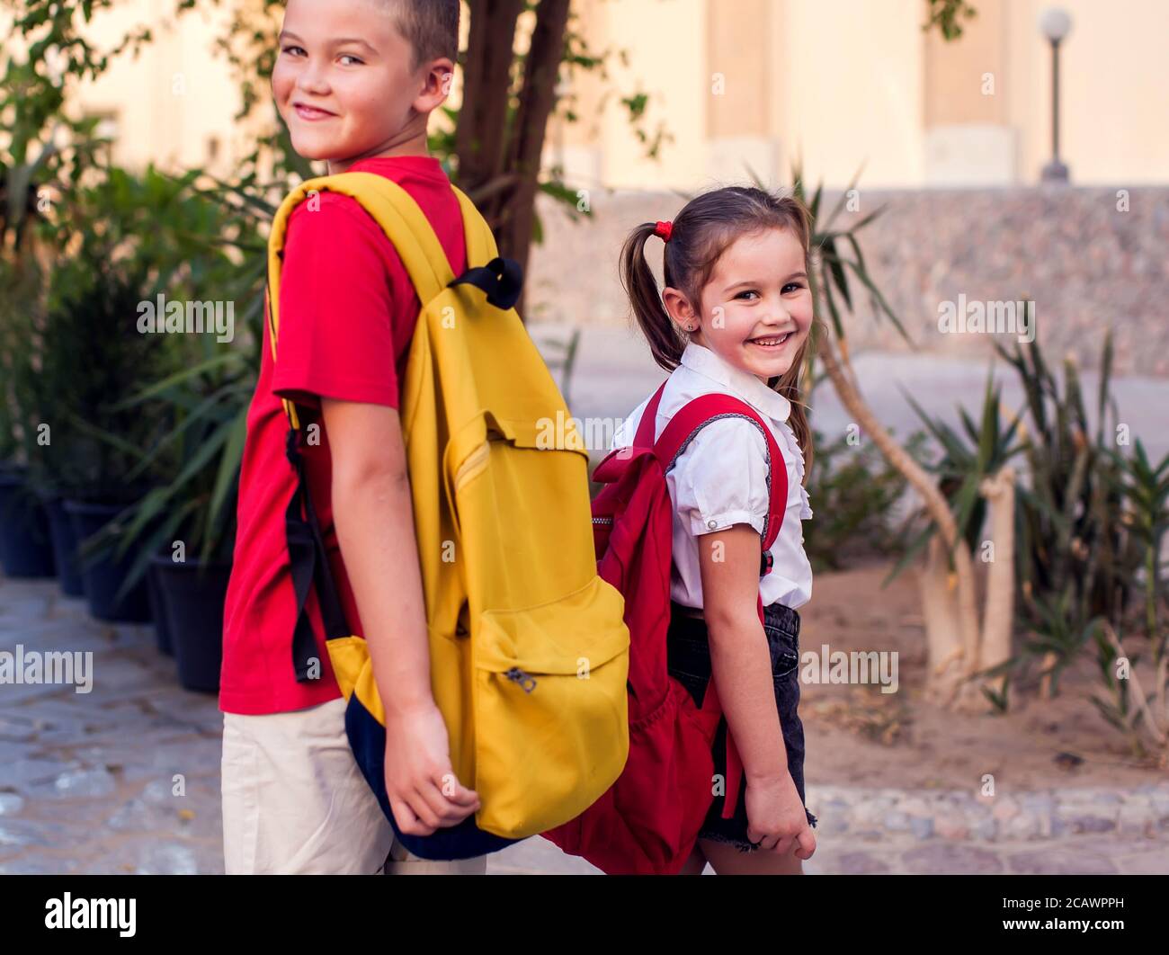Back to school. Pupils with backpacks staying outdoor Stock Photo - Alamy