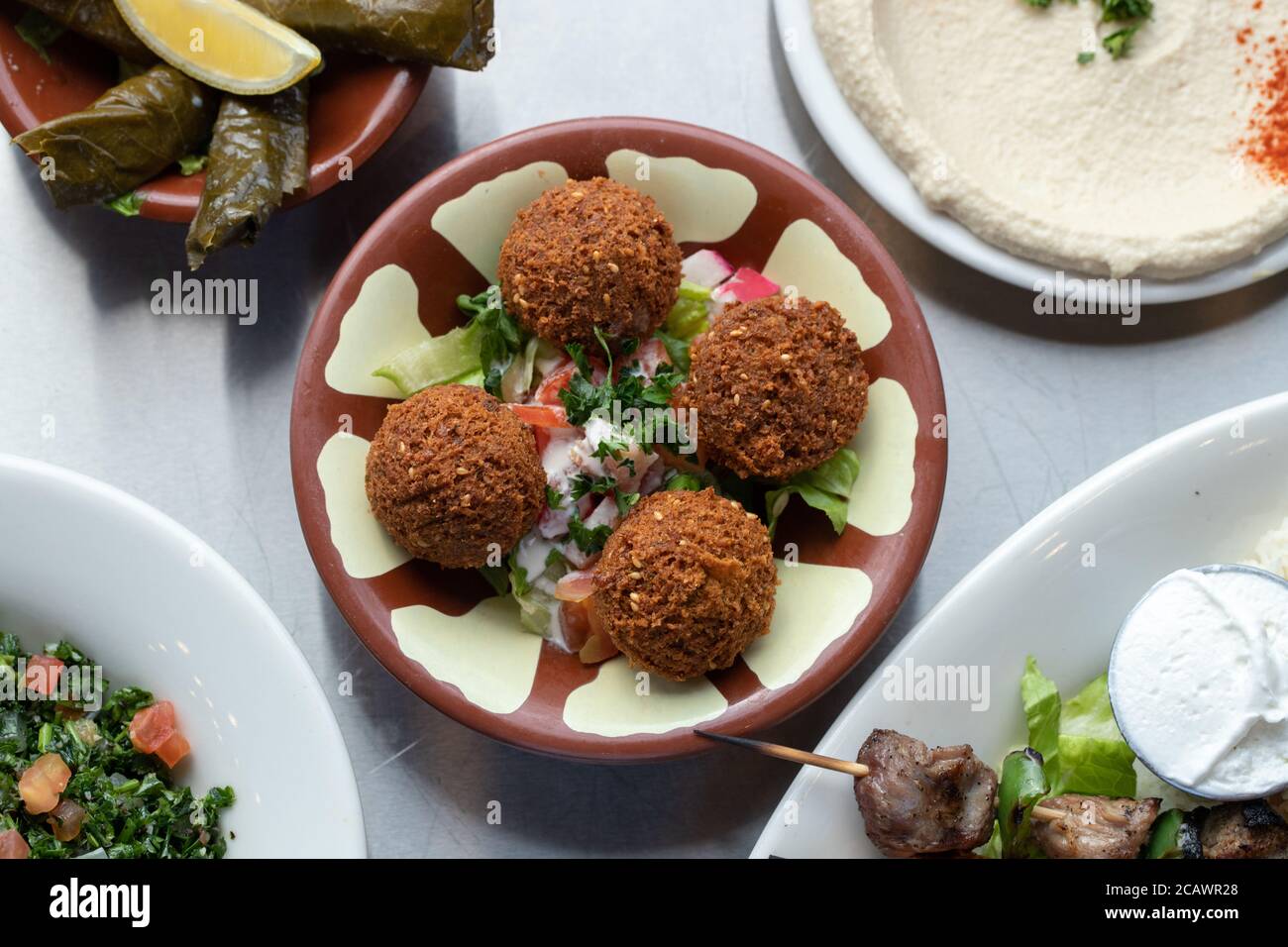 Top view of falafel with ingredients in a plate and some other dishes ...