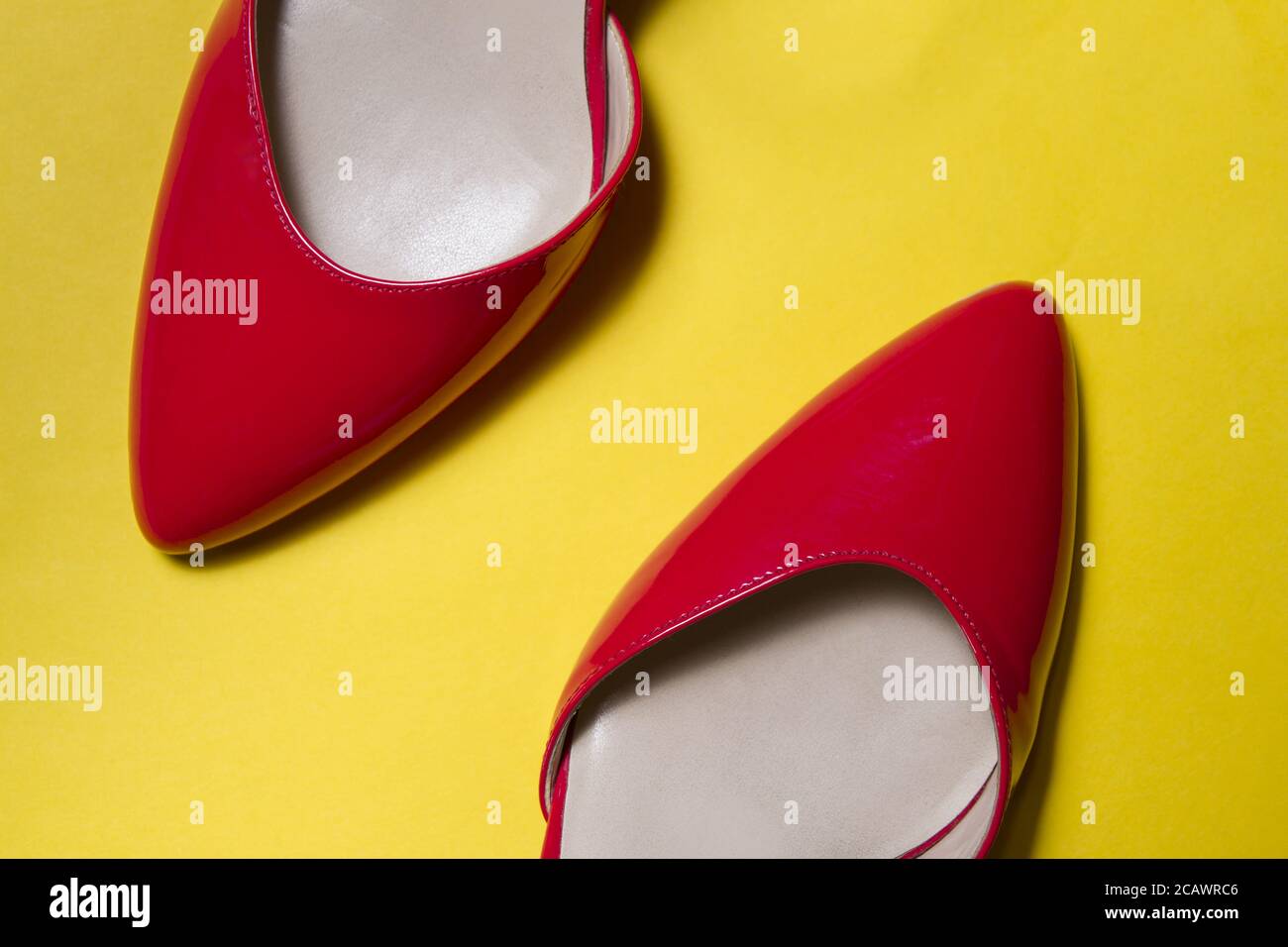 Overhead shot of vivid red woman shoes on a yellow background Stock ...