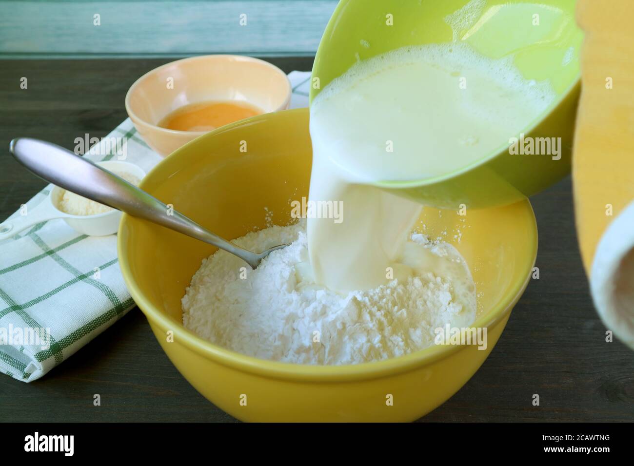 Pouring hot milk into tapioca flour for baking Brazilian cheese bread ...