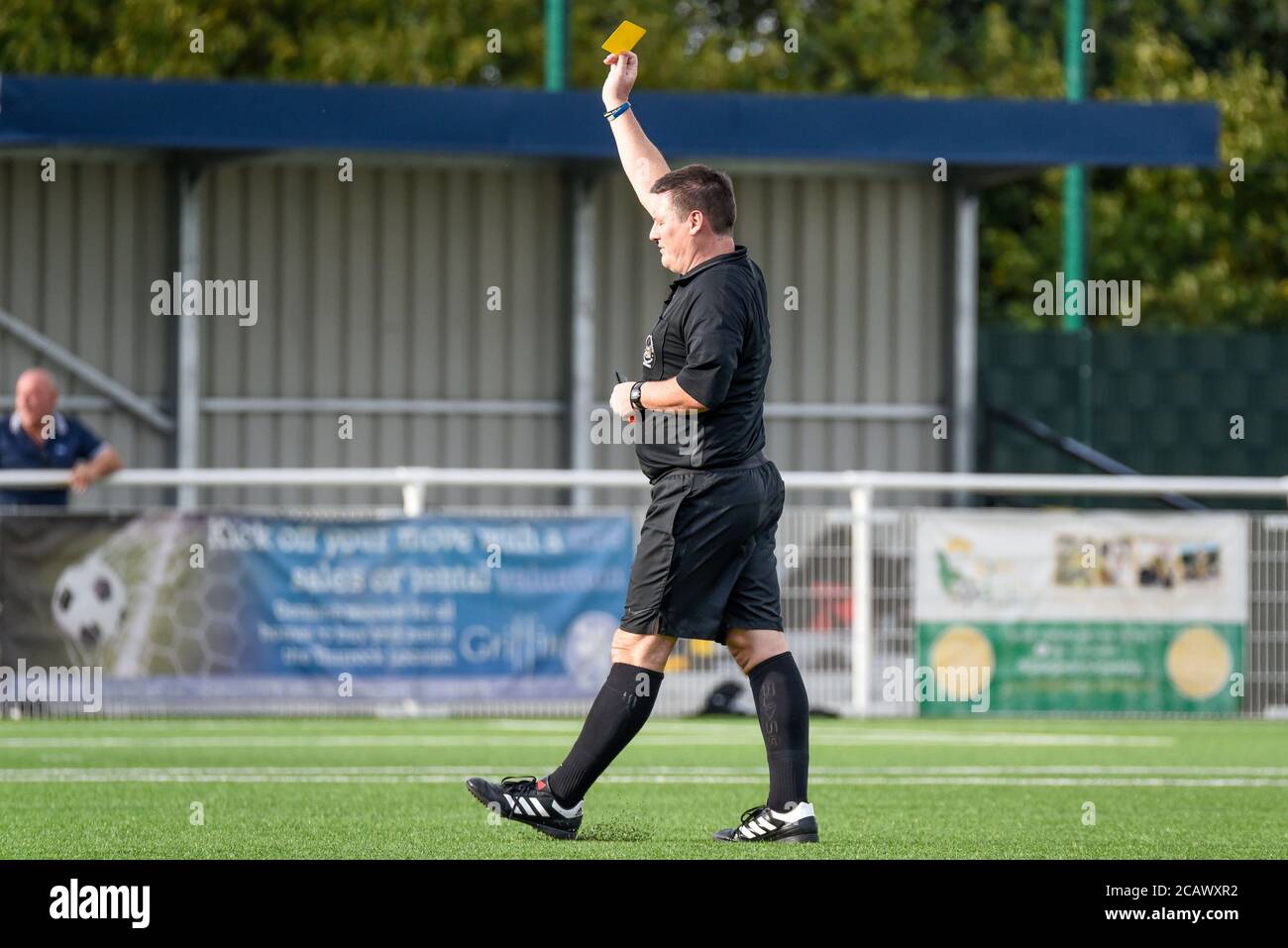 Referee raising yellow card at a football match at Aveley FC Parkside ...