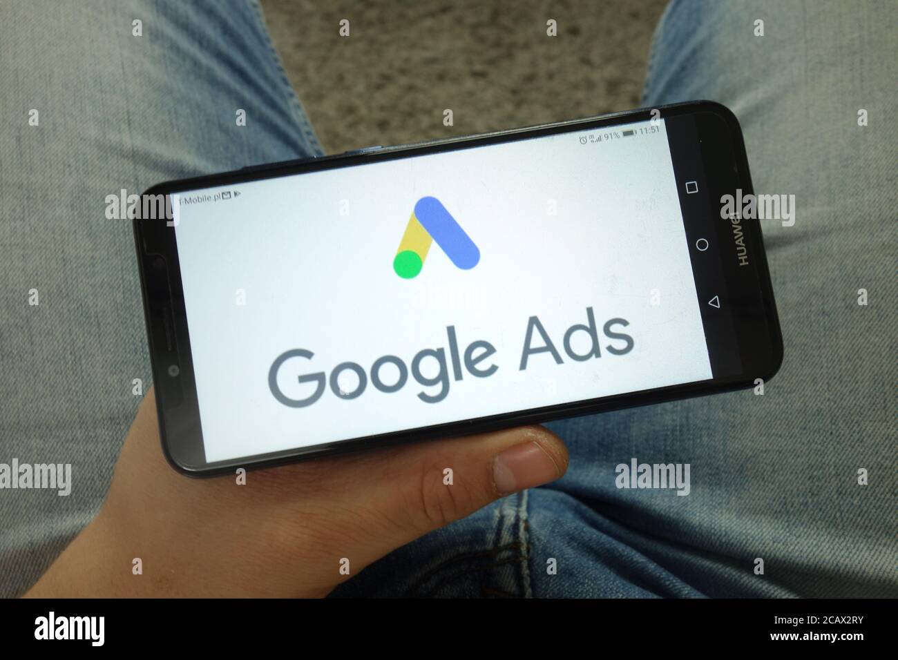 Man holding smartphone with Google Ads online advertising platform logo ...