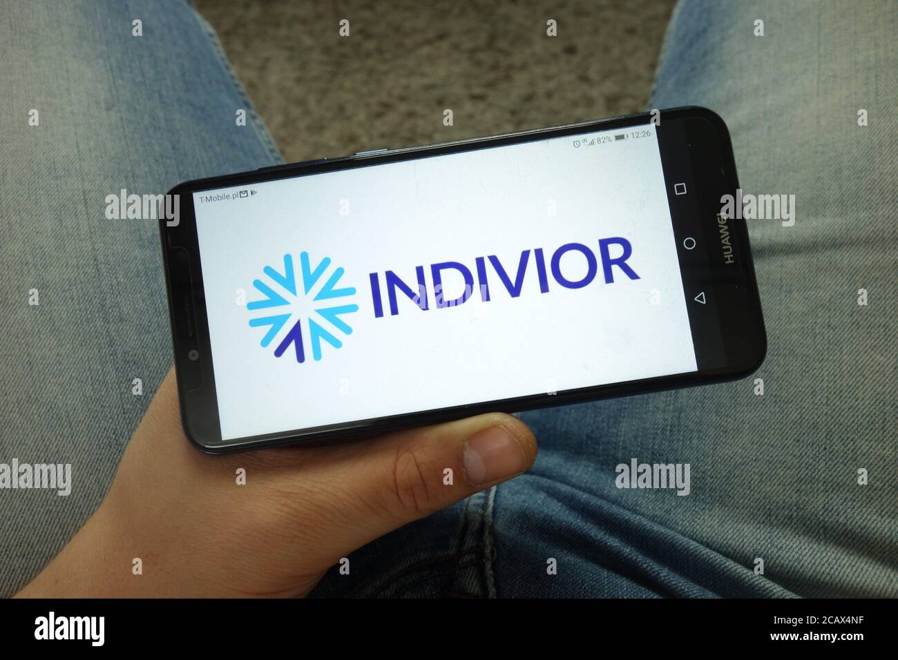 Man holding smartphone with Indivior pharmaceutical company logo Stock ...