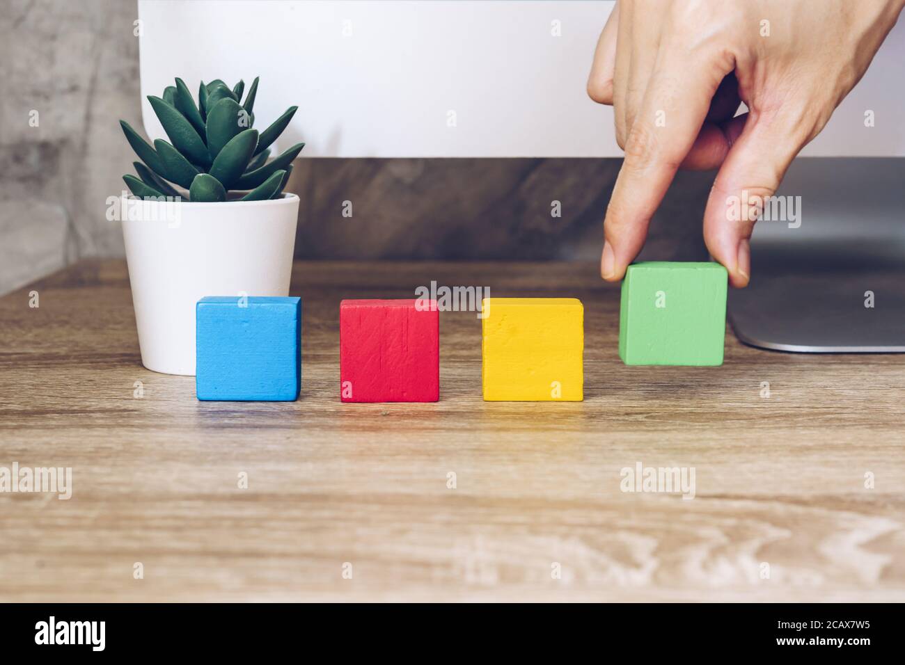 Hand arranging wood block stacking as step stair on wooden table ...