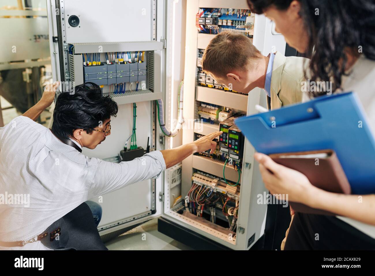 Small factory owner showing control locker to inspectors Stock Photo ...