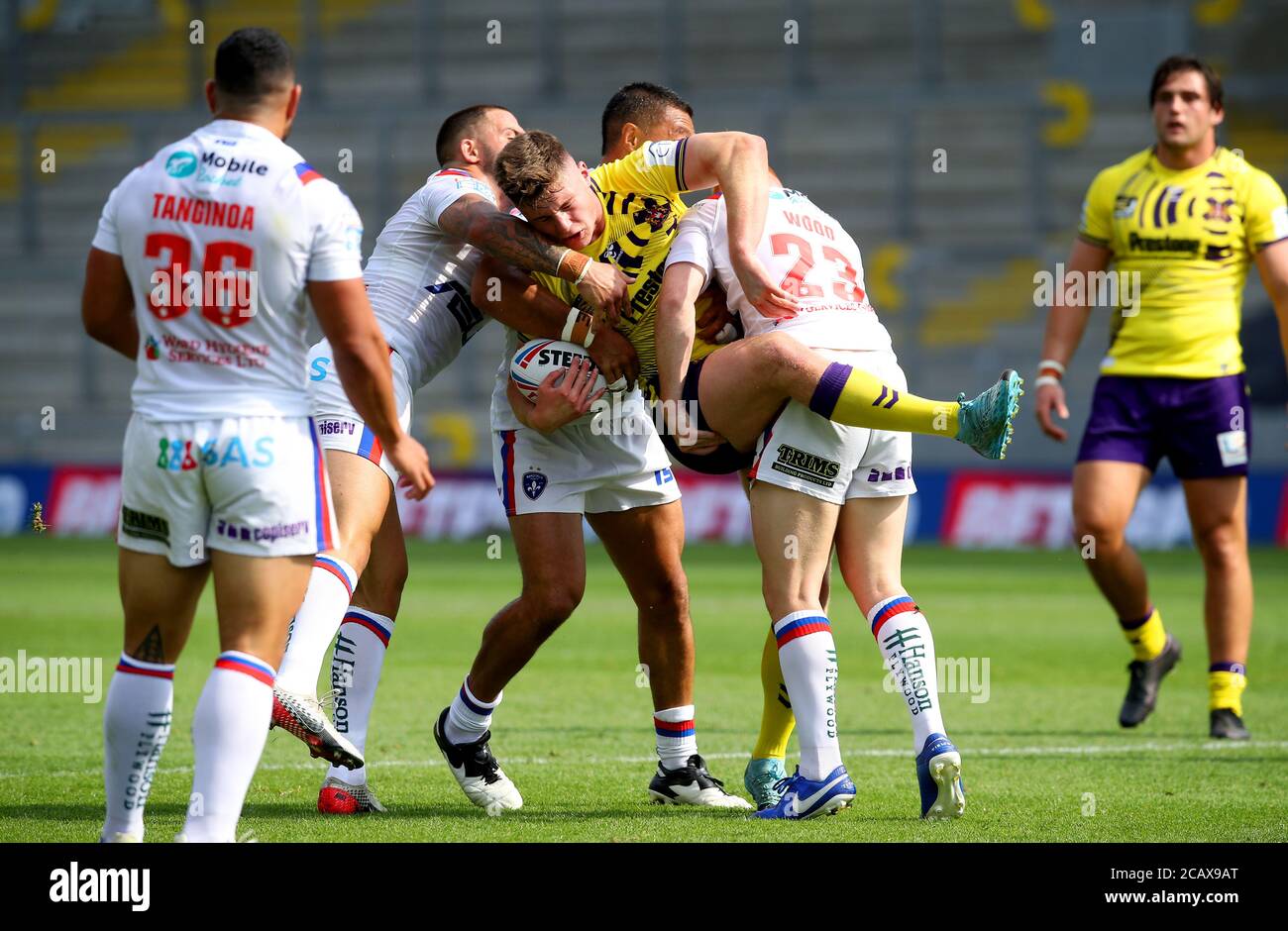 Wigan Warriors' Ethan Havard (centre) is tackled by Wakefield Trinity's ...