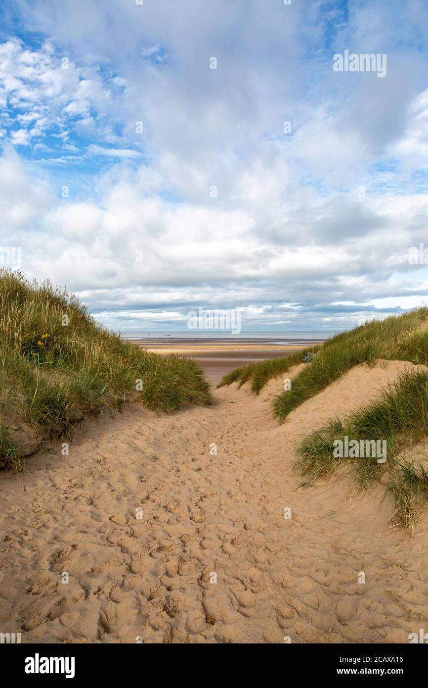 Looking along a pathway through sand dunes, leading to the sandy beach ...