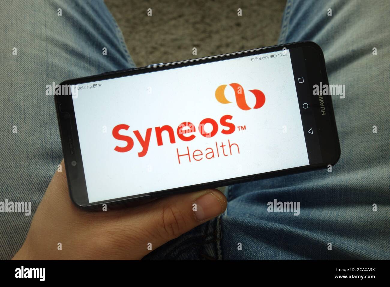 Man holding smartphone with Syneos Health company logo Stock Photo - Alamy