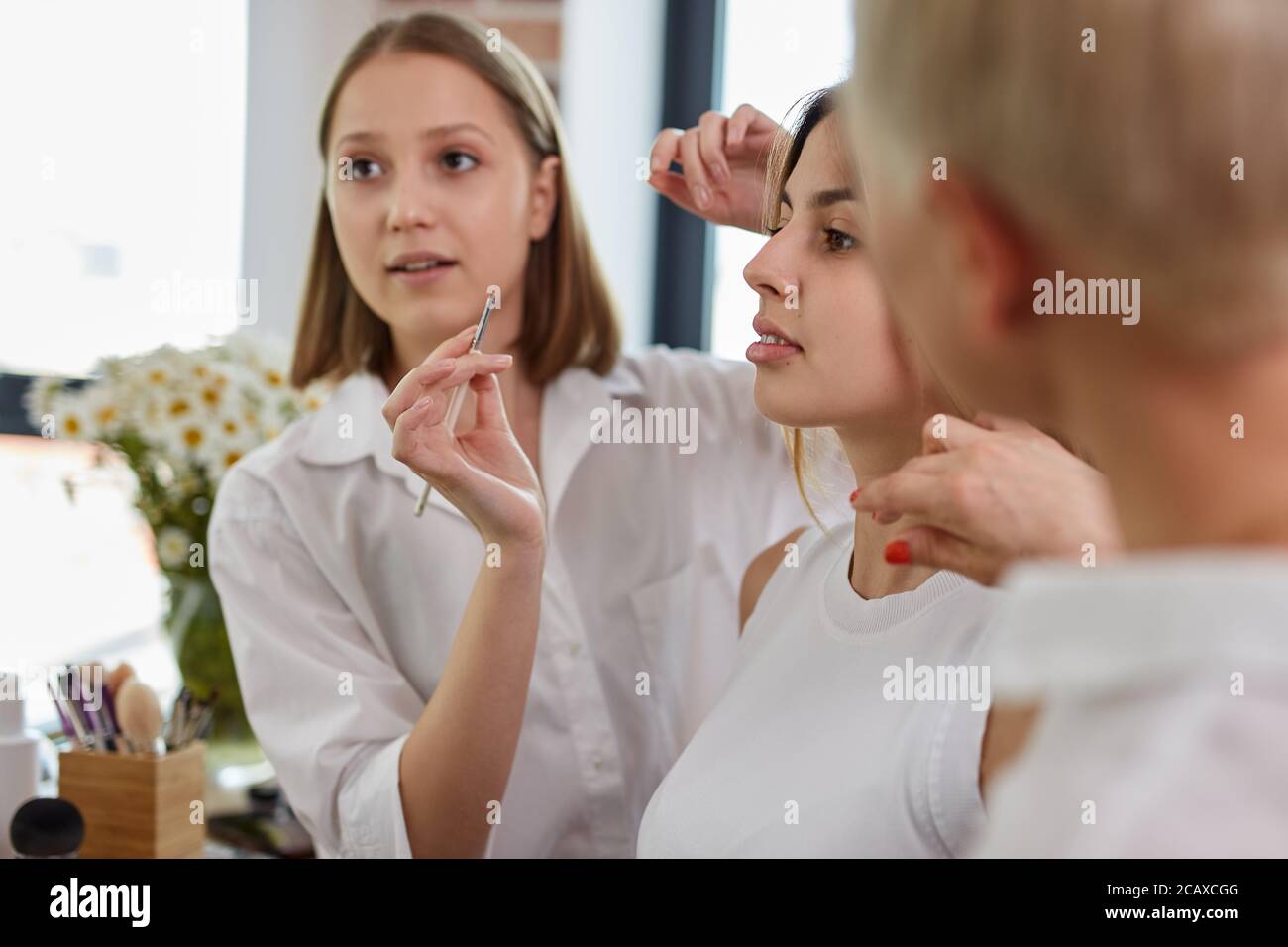 process of making makeup in beauty salon. visagiste working with brush ...
