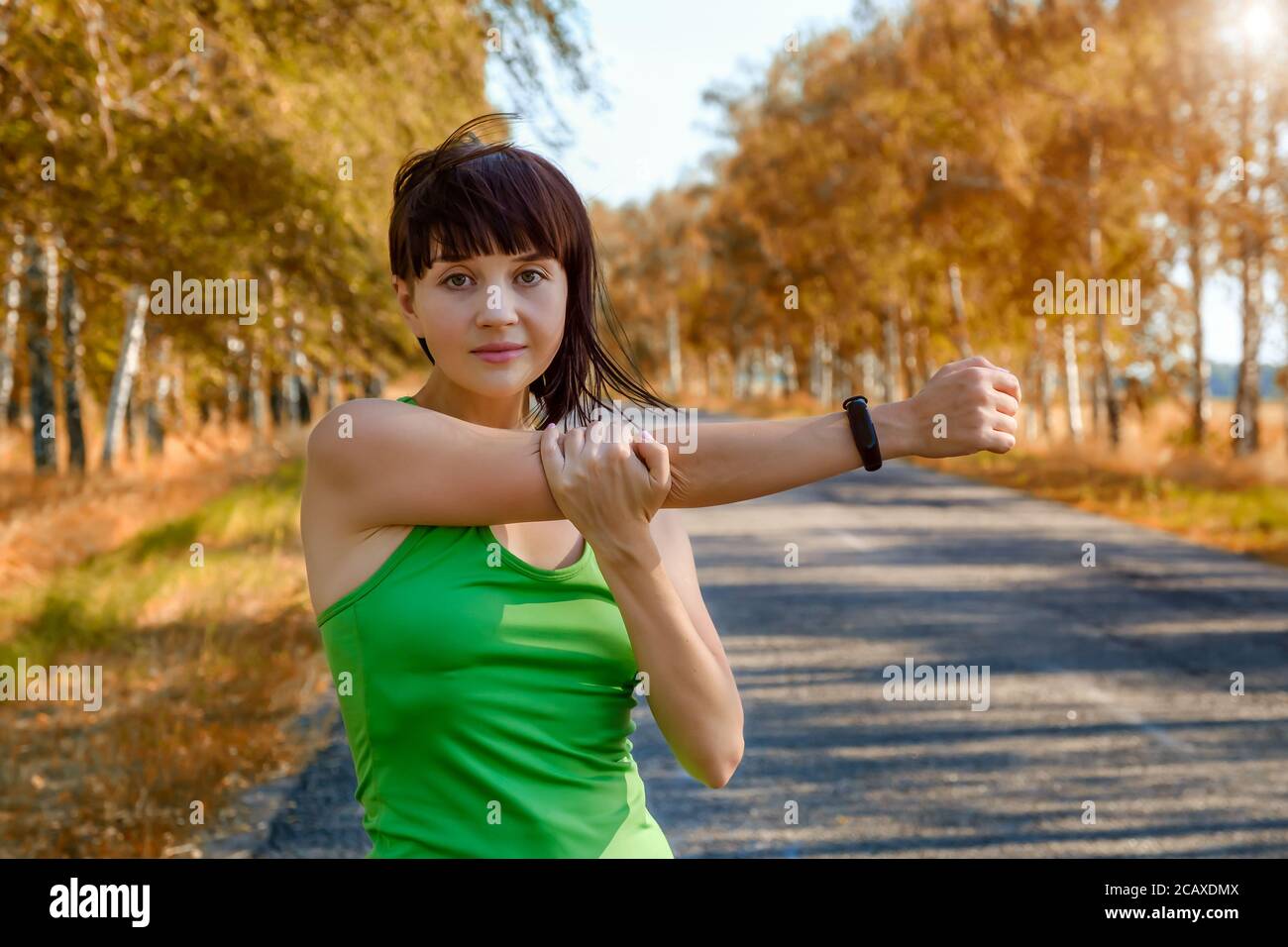 fitness woman, wearing a smartwatch activity tracker, stretching her ...