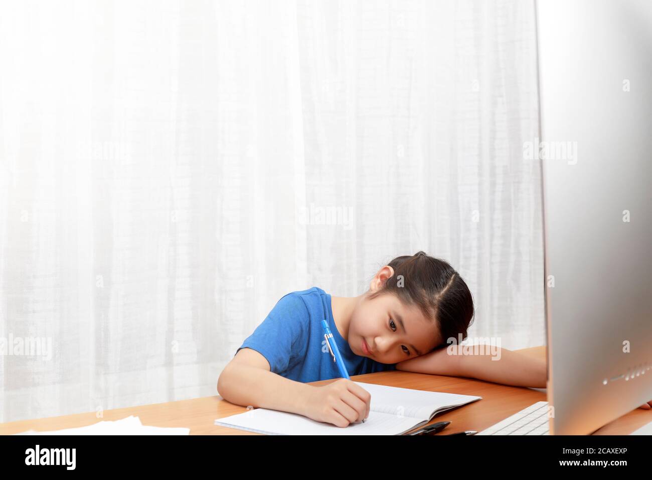 Asian young little girl using pencil to do homework by herself. Student ...