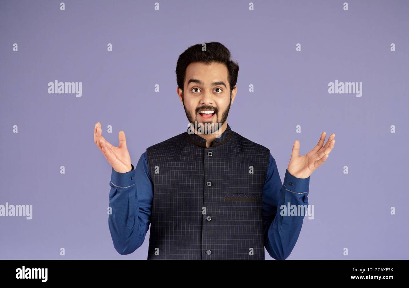 Handsome Indian man expressing excitement on lilac background Stock ...