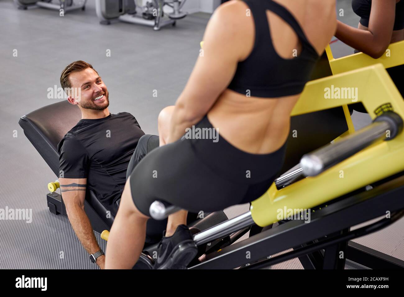 athletic people support each other in gym, do exercises together. man ...