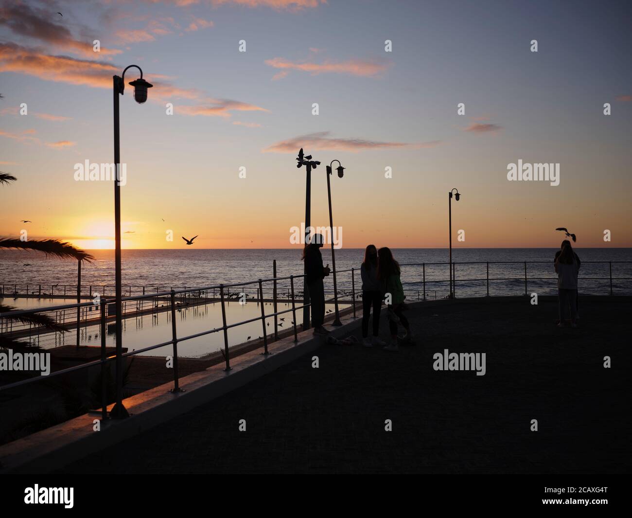 People enjoying the sunset on the Sea Point Promenade in Cape Town ...