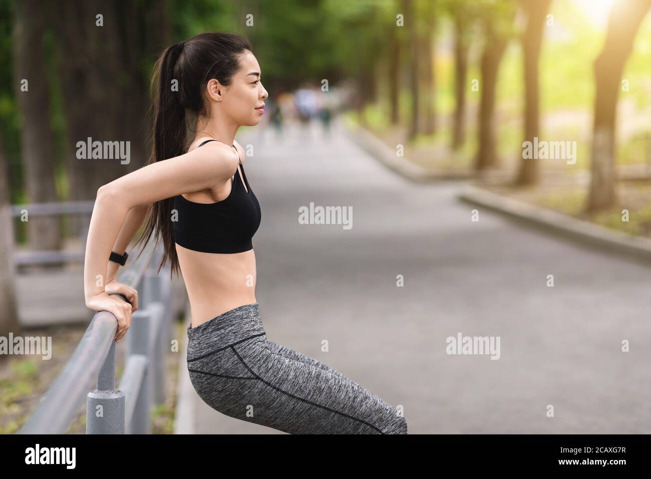 Outdoor Training. Asian Girl Exercising With Handrail In Park, Making ...