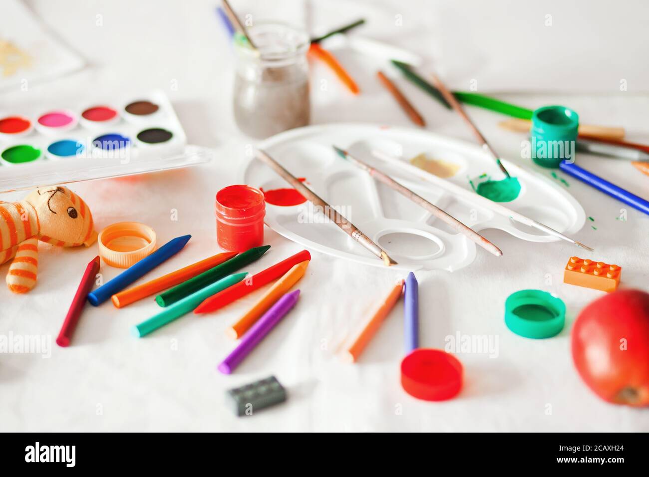 Brushes, paints, gouache and colorful pencils on the table. Children's ...
