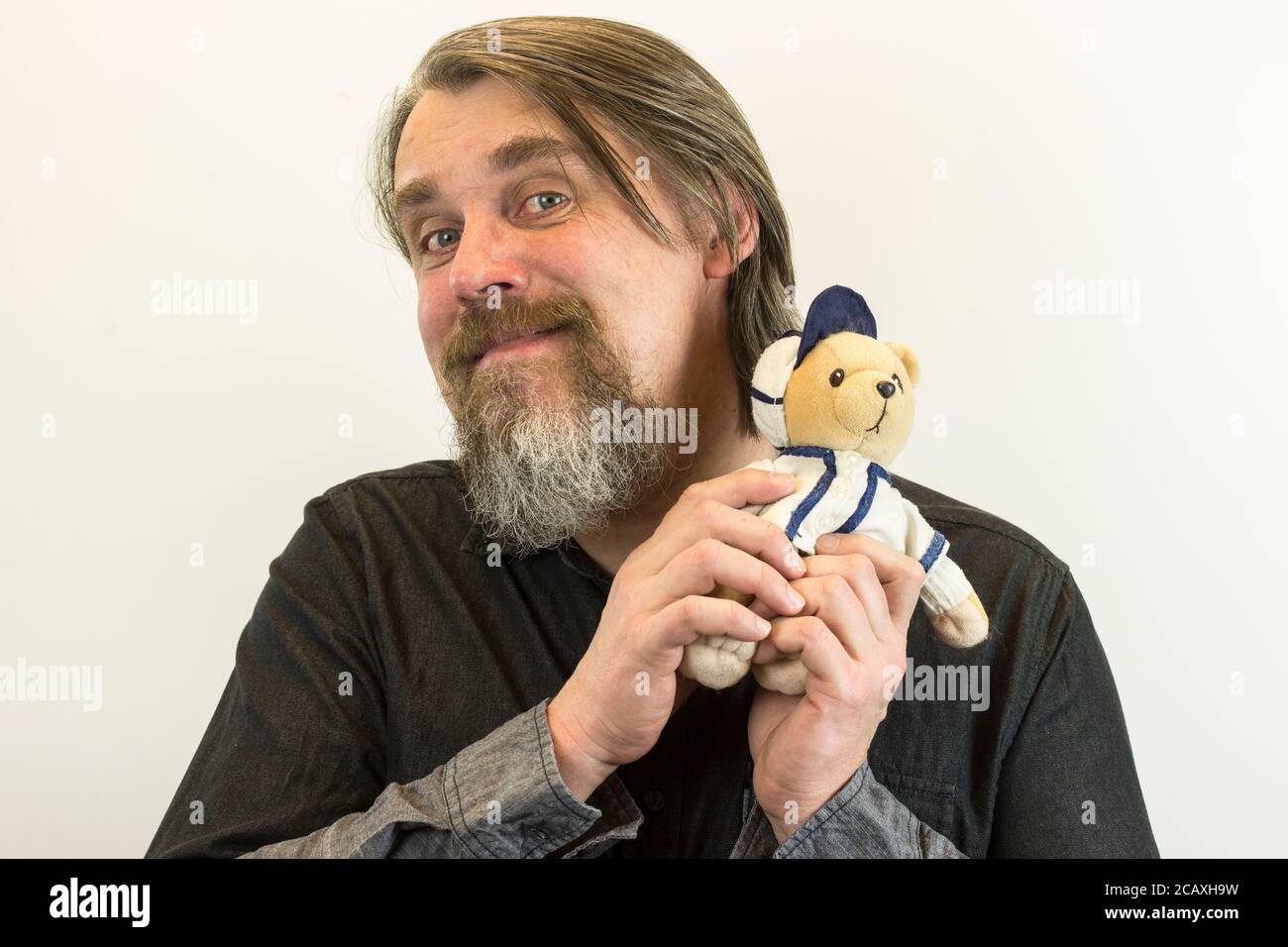 Brutal man with happy face plays with soft toy. Pretty toy concept. Man ...